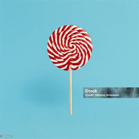 파란색 배경에 화려한 롤리팝 나무 막대기 빨간색과 흰색 나선형 어린 시절 과자 크리스마스 개념 건강에 좋지 않은 음식에 대한 스톡 사진 및 기타 이미지 Istock