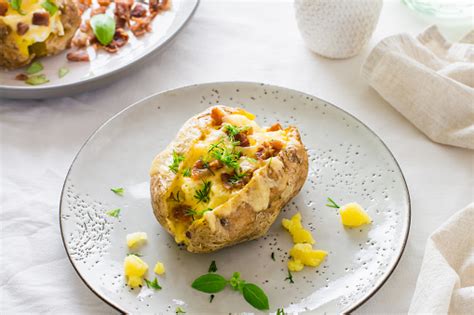 나무 테이블에 접시에 치즈와 베이컨 부스러기로 두 번 구운 감자를 피부에 식욕을 돋우는 플렉시타리안 다이어트 클로즈업 속채운 감자에 대한 스톡 사진 및 기타 이미지 Istock