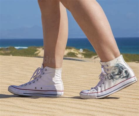 Close Up Of Woman Legs Wearing A Pair Of Red Sneakers Isolated On