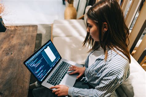Young Woman Mobile Developer With Laptop Writes Program Code On A