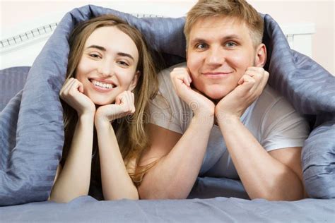 Cute Loving Couple Is Lying On The Bed In The Bedroom In The Morning