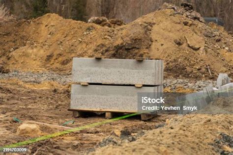 콘크리트 블록 더미가 자갈과 흙 사이로 팔레트 위에 놓여 있으며 도시 거리를 따라 건설 현장에서 수리 작업이 진행 중입니다 0명에 대한 스톡 사진 및 기타 이미지 Istock