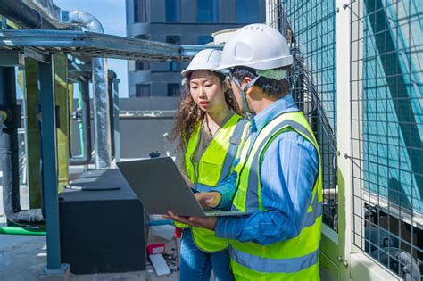 산업 냉수 팬 코일 단위 에어컨을 점검하는 엔지니어는 공기 시스템을 제어하는 대형 산업 건물의 물 냉각탑 공기 냉각기 Hvac 시스템입니다 20 24세에 대한 스톡 사진 및