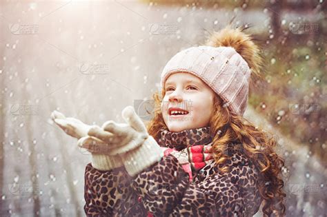 小女孩伸手去接雪花。