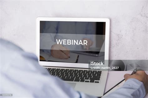 노트북 컴퓨터에서 웨비나를 시청하고 학습을 위한 노트북에 글을 쓰는 사람의 손 온라인 E러닝 교육 화상 컨퍼런스 및 교육 세미나 과정 디지털 학습 계획에 대한 스톡 사진 및