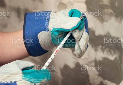 테이프를 측정 하 여 작성기의 손입니다 수리 건물 개념을 홈장갑 측정 테이프를 가진 벽에에서 남자의 닫습니다 개선에 대한 스톡
