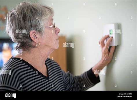 Senior Woman Adjusting Her Thermostat Stock Photo Alamy