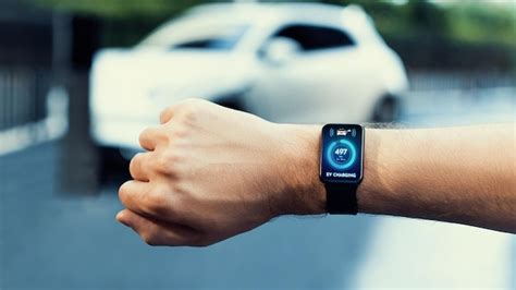 사업가는 충전소에서 충전하는 동안 스마트 워치 화면에서 Ev 자동차 배터리 상태를 확인합니다 도시 주차장 Ev 기술 적응을 위한 청정 에너지의 미래의 라이프 스타일