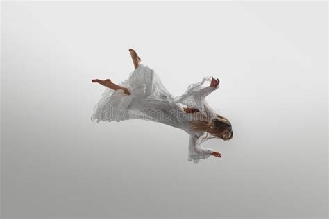 woman dressed in vintage white gown suspend in mid air her long blonde