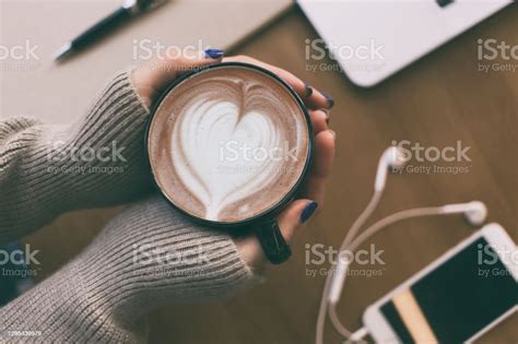 상단에 하트 모양 라떼 아트 노트북 스마트 폰과 테이블에 선인장 냄비와 뜨거운 커피 한 잔을 들고 여성의 손 라떼에 대한 스톡 사진 및 기타 이미지 Istock