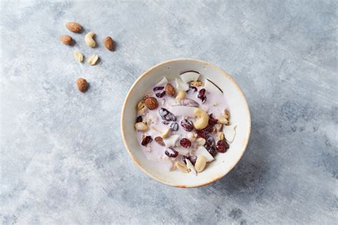 요구르트 견과류 크랜베리 코코아넛을 곁들인 그래놀라 그릇 맛있고 건강한 식사를 위한 컨셉 돌 배경입니다 맨 위 보기 공간을 복사합니다 0명에 대한 스톡 사진 및 기타 이미지