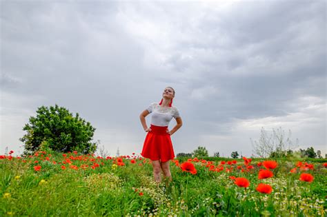 빨간 치마와 흰색 셔츠에 금발의 젊은 여자 빨간 귀걸이는 양귀비 필드의 중간에 가냘픈에 대한 스톡 사진 및 기타 이미지 가냘픈 귀걸이 금발 머리 Istock