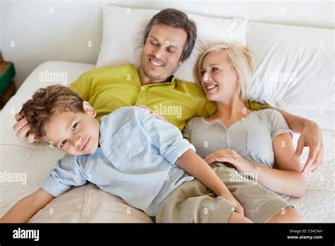 Parents With Their Son Relaxing In Bed Stock Photo Alamy