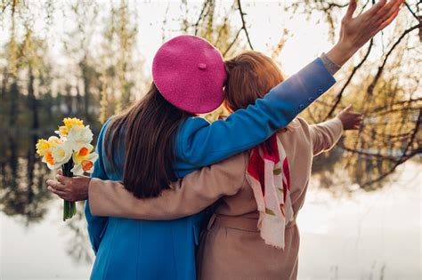 꽃과 그녀의 성인 딸과 함께 수석 어머니 봄 강에 의해 포옹 어머니의 날 개념입니다 패밀리 값 가족에 대한 스톡 사진 및 기타