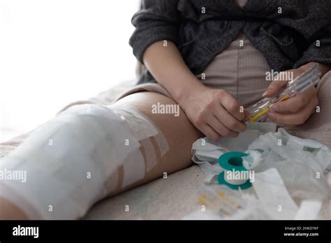 Close Up Shot With A Young Woman Getting Ready To Take Her Injection After An Acl Surgery Stock