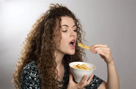 ПОДРОСТОК ЕСТЬ ШАР КАРТОФЕЛЬНЫХ СТРУЖЕК Стоковое Фото изображение насчитывающей женщина