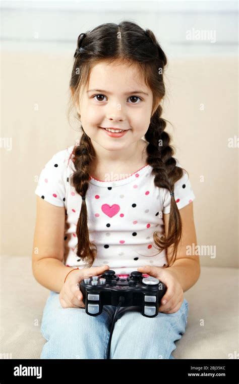 Happy Caucasian Girl Playing Video Games Holding Game Controller Sitting On Coach Living Room