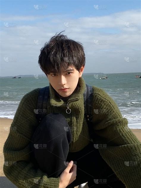 年轻男性坐在海边的沙滩上