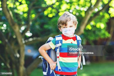 의료 마스크와 배낭 이나 가방 행복 한 어린 아이 소년 학교에 가는 길에 학교 키드 야외에서 건강한 아이 코로나 전염병 잠금에서 격리 시간 후 학교로 돌아가기 코로나