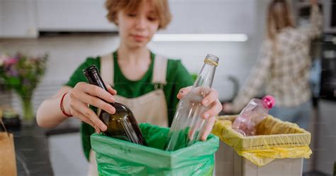 부엌의 재활용 쓰레기통에 유리병을 던지는 십대 소녀 사진 Unsplash의 폐기물 관리 이미지