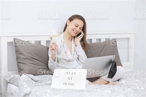 침실에서 노트북 컴퓨터에서 작업 하는 물 한 잔아름 다운 행복 한 젊은 여자입니다 집에 있어 프리랜서 쓰기 입력 소셜 앱을