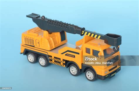 이 이미지는 이동식 붐과 후크가 달린 노란색 장난감 크레인 트럭을 묘사하고 있으며 상상력 놀이와 건설 테마 활동을 위해 설계되었습니다 건설 산업에 대한 스톡 사진 및 기타