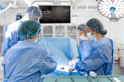 긴급 수술 전문 똑똑한 지능형 외과 의사는 환자 근처에 서서 자신의 생명을 구하는 동안 수술을 수행 공동체에 대한 스톡 사진 및 기타 이미지 Istock