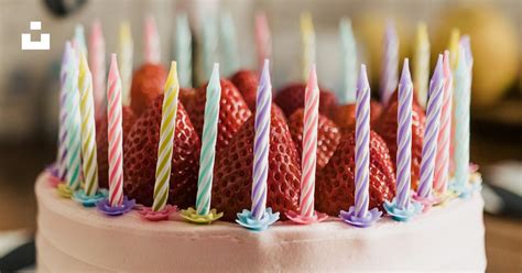 다양한 색상의 양초가 있는 흰색과 분홍색 컵케이크 사진 Unsplash의 무료 케이크 이미지