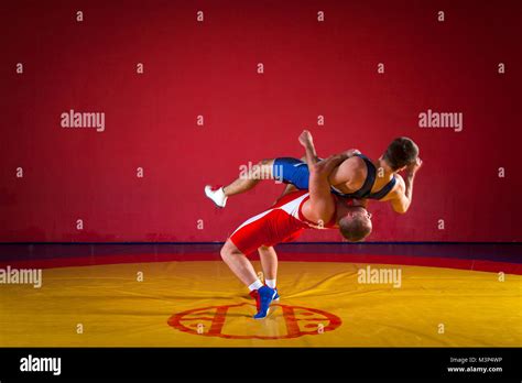 Two Greco Roman Wrestlers In Red And Blue Uniform Making A Suplex