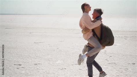 Happy Cheerful Attractive Woman Jumping On Man Hugging And Kissing Him Happy Lovely Couple