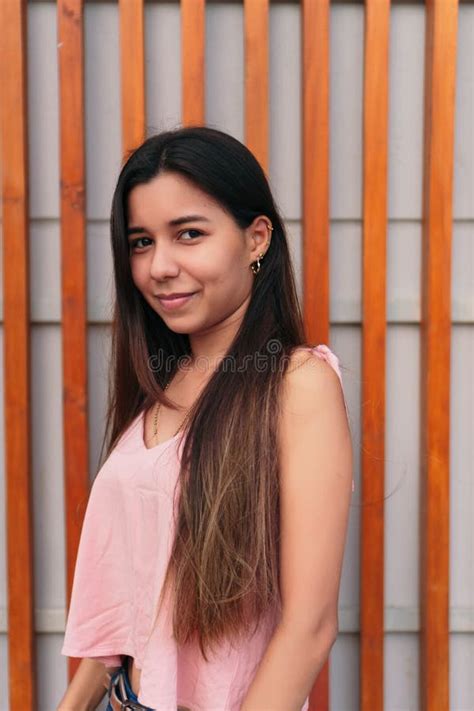 Young Latina Girl Wears Casual Clothes And Long Hair Laughs Outdoors
