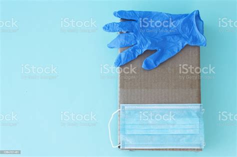 파란색 라텍스 장갑과 의료 용 마스크의 상단 보기는 밝은 파란색 배경에 골판지 상자 소포에 거짓말 텍스트 공간 안전한 배달 개념 0명에 대한 스톡 사진 및 기타 이미지