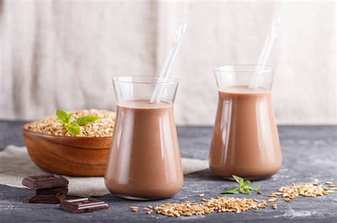 검은 콘크리트 배경에 귀리 씨앗이있는 유리와 나무 접시에 유기농 비 유제품 귀리 초콜릿 우유 비건 건강 식품 개념 클로즈업 사이드 뷰 귀리에 대한 스톡 사진 및 기타 이미지