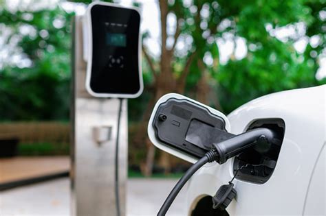 초점 근접 촬영 Ev 자동차와 진보적인 개념을 위한 흐릿한 배경의 충전기 금융에 대한 스톡 사진 및 기타 이미지 금융 전기 자동차 대체 연료 자동차 가리키기 Istock