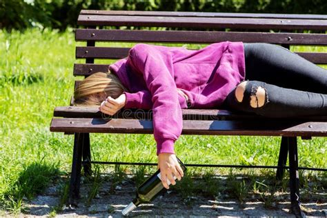 Молодая пьяная женщина таблицей и с пустой бутылкой Стоковое Фото изображение насчитывающей