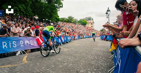 한 남자가 자전거를 타고 많은 사람들 옆 거리를 달리고 있습니다 사진 Unsplash의 무료 사이클리스트 이미지