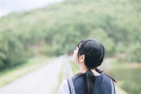 亚洲日本学校女孩服装与小花漫步在公园户外 包图企业站