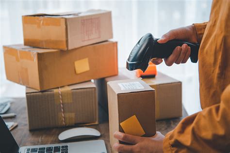 바코드 스캐너가 있는 골판지 상자를 스캔하는 배달 직원이 고객을 위한 제품을 확인합니다 경영자에 대한 스톡 사진 및 기타 이미지