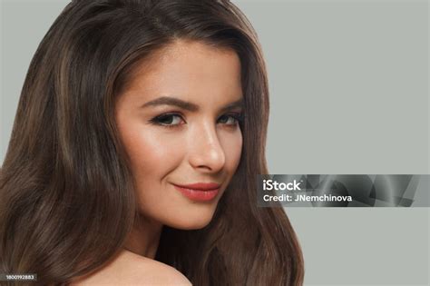 회색 배경에 길고 어두운 건강한 웨이브 머리와 메이크업을 가진 쾌활한 여자 갈색 머리 아름 다운 얼굴 클로즈업 스튜디오 인물 사진 25 29세에 대한 스톡 사진 및 기타