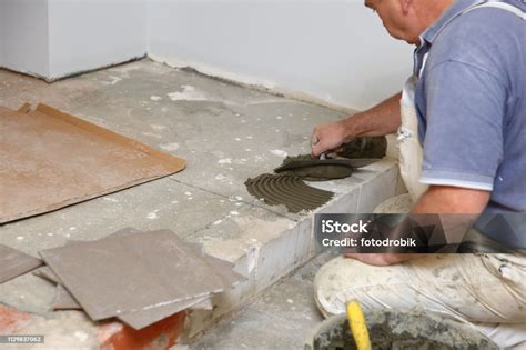 건설 노동자는 균등 하 게 시멘트 접착제 질량 특별 한 손 도구를 사용 하 여 계단의 표면 확산 건물의 층에 대한 스톡 사진 및