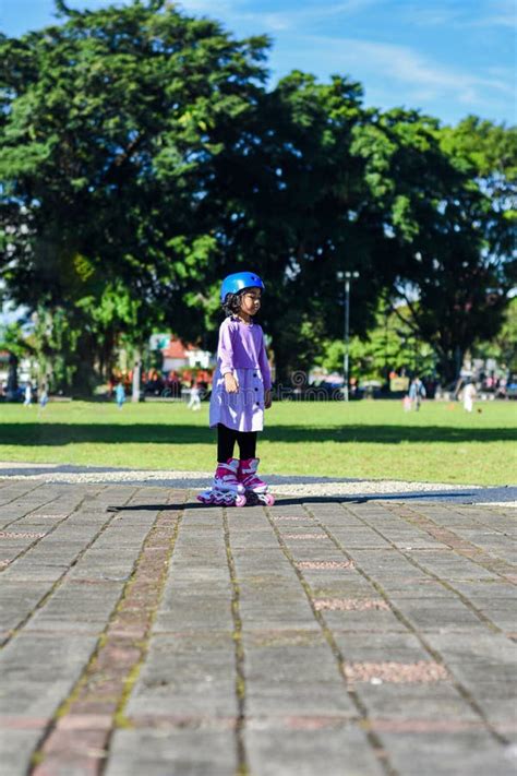 Little Pretty Girl On Roller Skates In Helmet At A Park Editorial