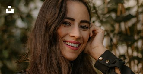 긴 갈색 머리를 가진 여자가 웃으며 손을 귀에 대고 있다 사진 Unsplash의 무료 초상 이미지