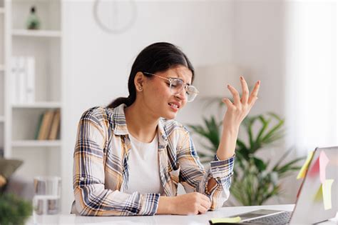 피곤한 어린 인도 소녀는 할 일의 수에 화를 내고 종이를 구겨서 버리고 명상을 통해 진정하려고합니다 스트레스가 많은 일과 공부 과로 격노한에 대한 스톡 사진 및 기타 이미지