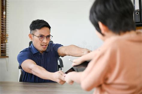 Angry Asian Dad Taking Out A Tablet From His Son Having Tablet Battle Fight Stock Image Image