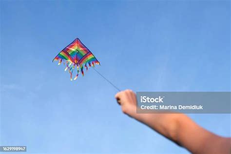 푸른 하늘에 연 레인보우 델타를 비행하는 행복한 십대 소녀 행복한 성장기의 순간 야외 시간 소비 포부 목표 영감 개념 자유와 여름 휴가 어린 시절의 꿈 연에 대한 스톡 사진