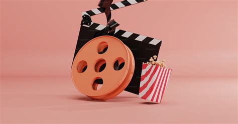 분홍색 배경에 필름 릴과 팝콘 한 봉지 사진 Unsplash의 필름 이미지