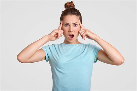 건 망 증 충격된 십 대 사원에 집게 손가락 입 널리 열린 입고 캐주얼 티셔츠 흰색 배경에 대해 포즈를 유지 사람 얼굴 표정 및 감정 개념 T 셔츠에 대한 스톡 사진 및