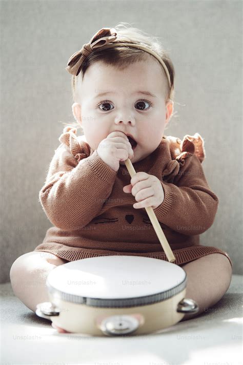 막대기를 입에 물고 바닥에 앉아 있는 여자 아기 사진 Unsplash의 소녀 이미지