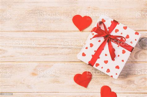 발렌타인 데이 또는 다른 휴일 수제 선물에 빨간 하트와 선물 상자가 있는 종이에 휴일 포장지 복사 공간 디자인을위한 빈 공간 오렌지 나무 테이블 상단보기에 선물 상자 개념에