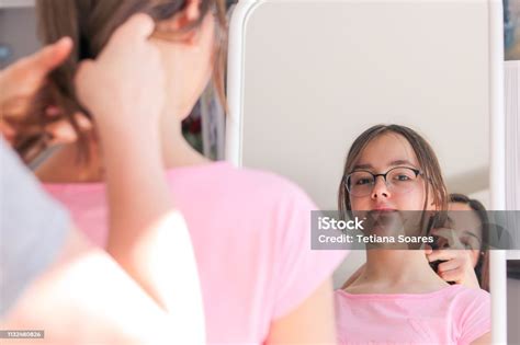아름 다운 웃는 십 대 소녀 안경에 거울에서 반사를 통해 카메라를 보고 머리를 만드는 그녀의 어머니를 하 고 있는 동안 여자 거울에 대한 스톡 사진 및 기타 이미지 Istock